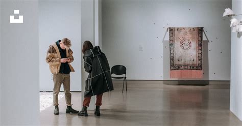 벽에 그림이 있는 방에 서 있는 두 사람 사진 Unsplash의 무료 층 이미지