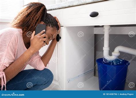 Woman Calling Plumber In Front Of Leaking Sink Pipe Stock Photo Image