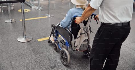 장애인 여성 여행자를 비행기로 수송하는 공항 남성 직원의 뒷모습 사진 Unsplash의 휠체어 이미지