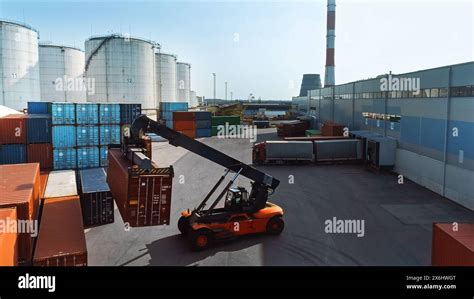 Aerial Shot Of A Container Handler Carrying A Large Red Shipping Cargo