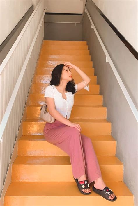 လှေကားထစ်လေးမှာ ကျော့ရှင်းစွာထိုင်းရင်း ဆံပင်လေးကို သပ်ပြီး အပြုံးချိုခ