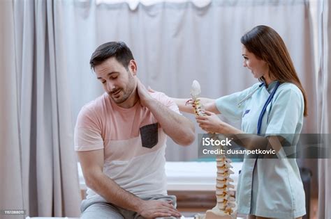 코 카 서 스 남성 환자는 목을 들고 간호사가 척추 모델을 잡고 환자를 검사 하는 동안 아픈 곳을 보여줍니다 물리치료사에 대한