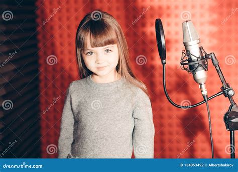 Niña Hermosa Con El Micrófono En Fondo Rojo Foto De Archivo Imagen De