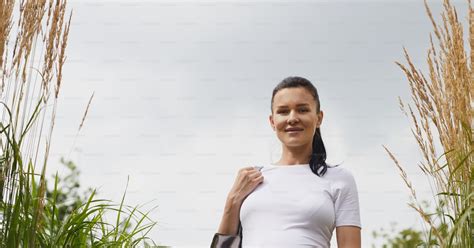 캐주얼 옷을 입은 아름다운 임산부의 초상화는 야외의 녹색 식물 사이를 따라 걷는 동안 카메라에 미소를 짓고 있다 사진 Unsplash의 청녀 이미지