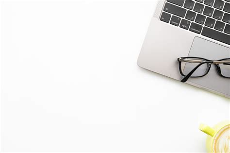 노트북 컴퓨터와 핫 라떼 커피 한 잔 아침 작업 개념흰색 사무실 책상 테이블 복사 공간 플랫 레이가 있는 상단 뷰입니다