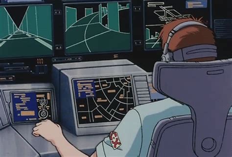 A Man Sitting In Front Of Two Computer Monitors