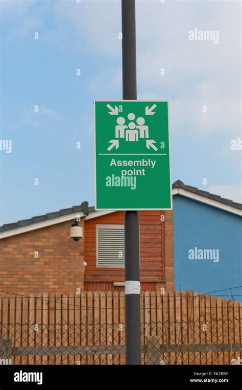 Sign For Assembly Point In Case Of Fire Mounted On A Pole At Workplace