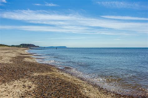 장엄한 푸른 하늘과 약간의 흰 구름 아래 고요한 맑은 물에 따라 배경에 언덕이 있는 아름 다운 야생 모래와 돌 밭의 전망 0명에 대한 스톡 사진 및 기타 이미지 Istock