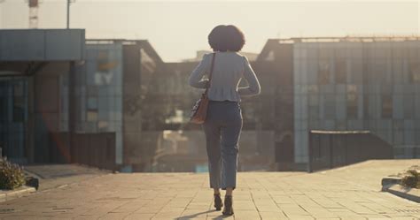 직장 기업 경력 및 직장을 위한 아침 출퇴근을 위해 도시에서 비즈니스 여성의 걷기 여행 및 등판 여행 여행 및 일몰에 사무실 건물까지 걸어가는 도시 거리의 여성 노동자