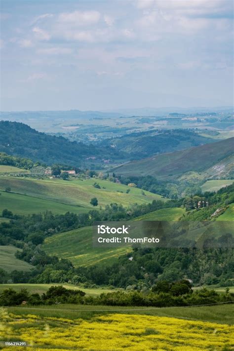 구불구불한 언덕 계곡 햇볕이 잘 드는 들판 구불구불한 시골 길을 따라 사이프러스 나무가있는 그림 같은 토스카나 풍경 언덕에 집