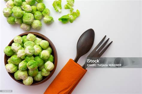 브뤼셀 콩나물 옆에 냅킨에 싸여 나무 포크와 숟가락은 나무 그릇에 놓여 있고 테이블에 흰색 배경이 있습니다 0명에 대한 스톡 사진 및 기타 이미지 Istock