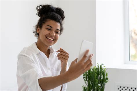 스마트 폰을 들고 셀카를 만드는 아름다운 미소 아프리카 계 미국인 여성 Brand Name Online Messaging Platform에 대한 스톡 사진 및 기타 이미지