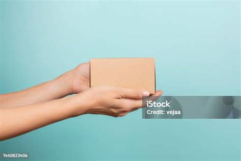 하늘색 배경에 작은 갈색 직사각형 판지 상자를 들고 있는 여자 모형 소포 상자 포장 쇼핑 배달 선물 선물 개념 갈색에 대한 스톡 사진 및 기타 이미지 Istock
