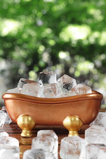 모델 빅토리아 스타일 구리 색상의 클로즈업 이미지 얼음 큐브 나무 바닥 검은 배경 건강 및 치료 개념으로 채워진 골드 발톱 발과 구리 색상의 독립형 곡선 롤 탑 욕조 0명에