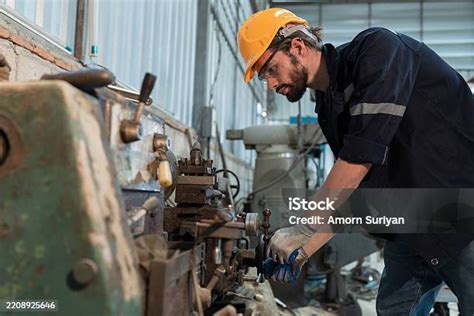 산업 공장의 전문 남성 엔지니어 유지 보수 선반 기계 안전 유니폼 고글 및 헬멧이 있는 선반 기계를 수리하는 엔지니어 20 24