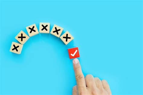 Premium Photo Hand Chooses Check Mark On Wooden Toy With Cross Symbol