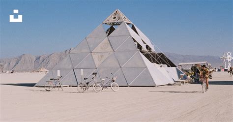 피라미드 모양의 구조물 앞에 자전거가 주차되어 있습니다 사진 Unsplash의 무료 블랙 록 시티 이미지