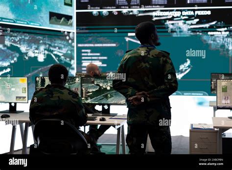 Army Conscript Examining Crucial Real Time Data On A Big Screen Gathering Information For