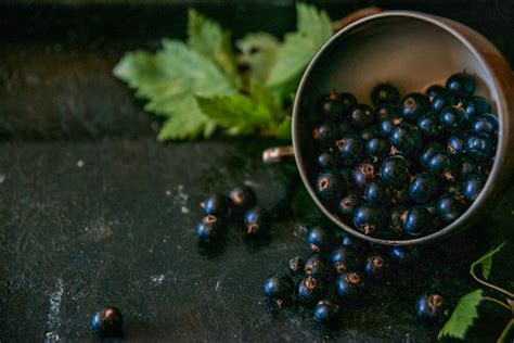 신선한 딸기 블루베리 듀 베리가 레드 건포도 어두운 금속 배경 위에 나무 접시에 검은 숯 크래커와 함께 무화과의 다양 한 공간이 최고 볼 수 있습니다 여름 어두운 간식 개념