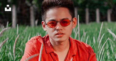 빨간 드레스 셔츠와 선글라스를 쓴 남자가 풀밭에 앉아 있습니다 사진 Unsplash의 무료 숲 이미지