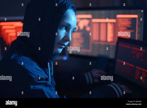 Girl Hacker In A Hood Typing Program Code While Committing A Cybercrime