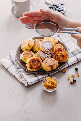 아침 식사로 차와 잼을 곁들인 커드 팬케이크 밝은 배경에 건포도와 코티지 치즈의 접시 건강 식품 빠른 아침 식사 조리법 0명에