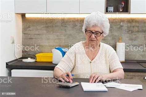 계산기와 종이계산을 가진 노인 여성은 집에서 계산합니다 사회 보장에 대한 스톡 사진 및 기타 이미지 사회 보장 지폐 계산기 Istock