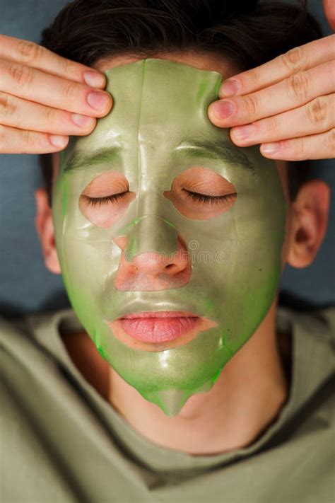 Young Man Using Green Face Mask With Hydrating Effect Male Beauty