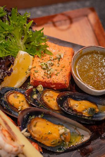 구운 해산물은 오징어 연어 홍합 태국 허브 및 야채를 나무 판에 해산물 소스가 담긴 작은 그릇과 함께 넣습니다 0명에 대한 스톡 사진 및 기타 이미지 Istock
