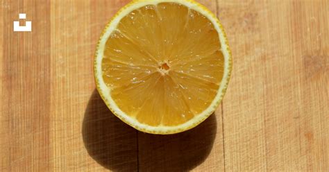 얇게 썬 레몬이 나무 표면에 놓여 있습니다 사진 Unsplash의 무료 음식 이미지