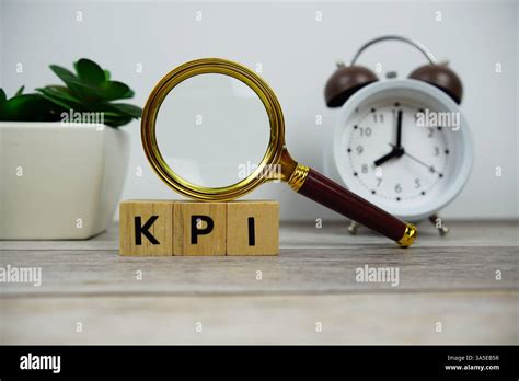 Magnifying Glass And Alarm Clock With Wooden Blocks Alphabet Letters Kpi Text Message On Wooden