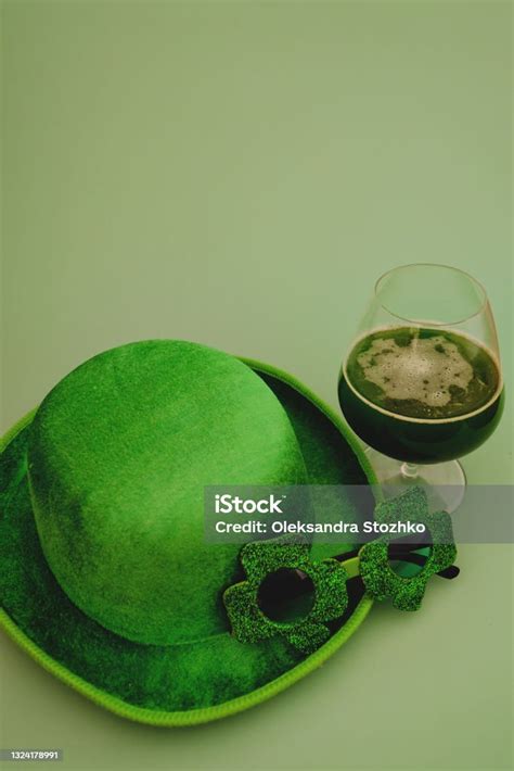 해피 세인트 패트릭의 날 개념 녹색 맥주 한 잔 녹색 배경에 파티 안경과 모자 인사말 카드 공간을 복사합니다 맨 위 보기입니다 St Patricks Day에 대한 스톡