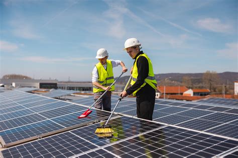 공장 건물 꼭대기에서 태양 전지판을 청소하는 두 명의 젊은 남성 노동자 20 24세에 대한 스톡 사진 및 기타 이미지 20