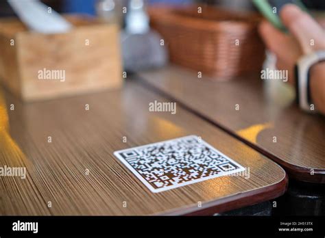 Closeup Of Guest Hand Ordering Meal In Restaurant While Scanning Qr Code With Mobile Phone For