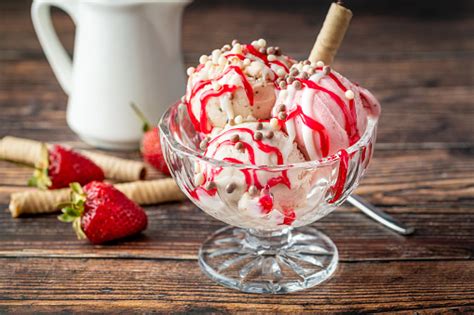 딸기 바나나 크림 로마 아이스크림을 레드 소스를 곁들인 유리 그릇에 담았다 0명에 대한 스톡 사진 및 기타 이미지 0명