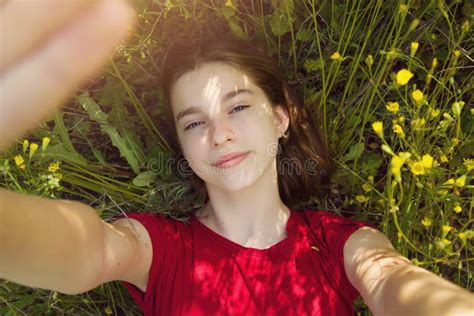 Happy Beautiful Young Girl Makes Selfie Photo Lying In The Thick Grass