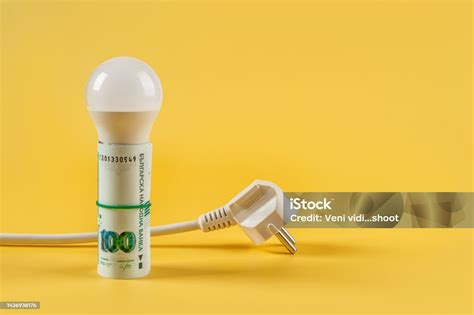 롤링 100 불가리아 레프 지폐에 전구와 노란색 배경 위에 흰색 전원 플러그 전력 위기와 인플레이션의 개념 불가리아의 에너지 비용 상승 공간을 복사합니다 0명에 대한 스톡