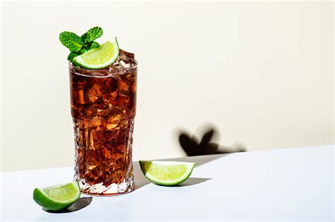 강한 알코올과 얼음을 곁들인 위스키 콜라 칵테일 하이볼 유리에 민트와 라임으로 장식 베이지색 배경 하드 라이트 0명에 대한 스톡 사진 및 기타 이미지 Istock