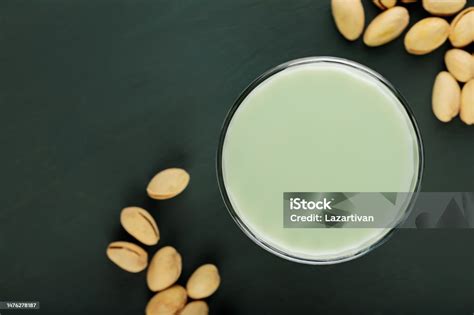 짙은 녹색 배경에 유리에 피스타치오 우유 건강한 유당이없는 피스타치오 우유와 피스타치오 비건 열매가 많은 식물성 우유 평면도 복사 공간 0명에 대한 스톡 사진 및 기타