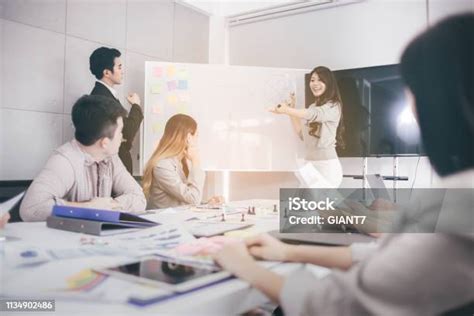 사업가 회의에서 동료에 게 제시 비공식적 인 사내 비즈니스 회의를 선도 하는 성공적인 팀 리더 및 비즈니스 소유자 전경에서 노트북에서 작업 하는 사업가 비즈니스 및 기업가