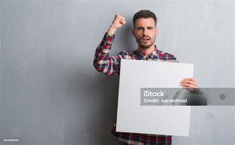 벽돌 벽 잡고 배너 화가 이상 젊은 성인 남자와 미친과 제기 손으로 소리 분노와 좌절 외치고 분노 개념 감정에 대한 스톡 사진