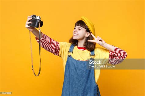 노란색 배경에 고립 된 승리 기호를 보여주는 레트로 빈티지 사진 카메라에 Selfie 샷을 하 고 프랑스 베 레모에서 소녀 십 대 웃는 사람들은 진심으로 감정 라이프 스타일