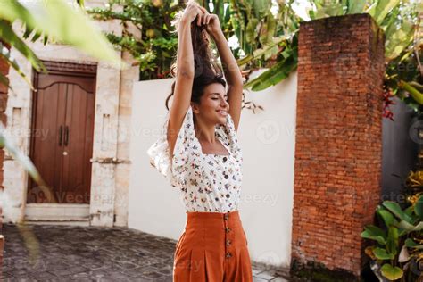 Happy Woman In White Blouse And Orange Skirt Raises Her Hands Up Long Haired Girl Posing In