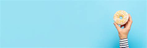 여성의 손은 파란색 배경에 도넛을 보유하고 있습니다 컨셉 제과 점 페이스트리 커피숍 기치 플랫 레이 상단 보기 도넛에 대한 스톡