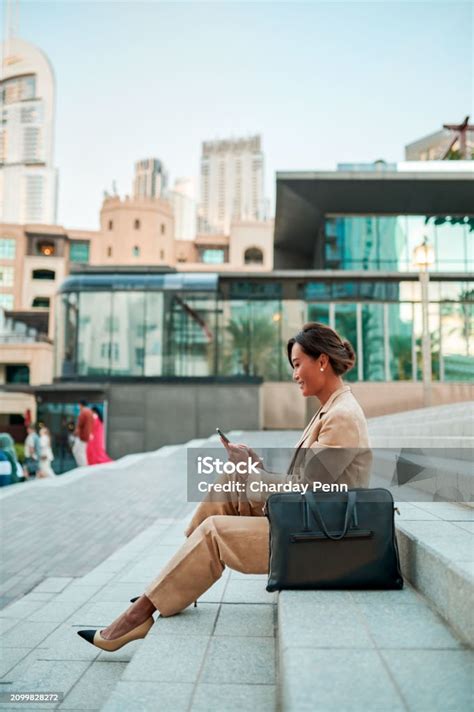 시내 중심가의 계단에 앉아 핸드폰으로 문자를 보내는 미소 짓는 아시아 사업가의 옆모습 초상화 50 54세에 대한 스톡 사진 및 기타 이미지 Istock