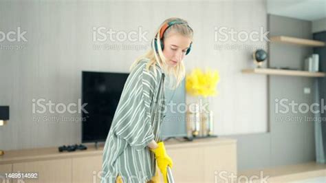 현대 진공 청소기로 바닥을 청소하는 젊은 여성과 집에서 헤드폰을 통해 음악을 즐기는 춤 바닥재에 대한 스톡 사진 및 기타 이미지 바닥재 청소하기 춤 Istock