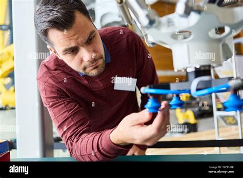 Engineer Focused On Programming A Robotic Arm For Industrial Automation