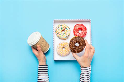 여성의 손이 파란색 배경에 도넛과 커피 한 잔을 들고있다 컨셉 제과 점 패스트리 커피 숍 배너 플랫 레이 상단 보기 끈적거리는에 대한 스톡 사진 및 기타 이미지 Istock