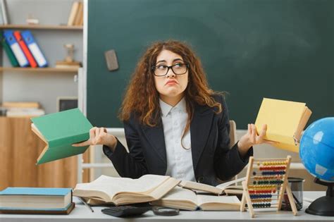 Free Photo Confused Young Female Teacher Wearing Glasses Holding