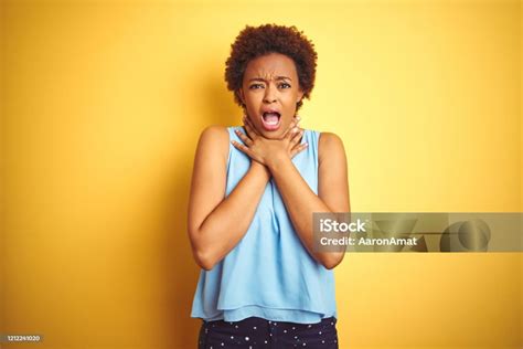 고립 된 노란색 배경에 우아한 셔츠를 입고 아름다운 아프리카 계 미국인 여성은 고통스러운 목졸림 때문에 외치고 질식합니다 건강 문제 질식 과 자살 개념 살인에 대한 스톡
